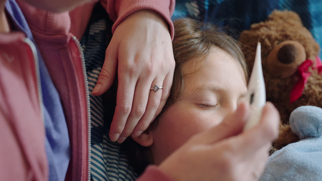 Mother Caring For Sick Child Lying In Bed With Flu Measuring Temperature Using Thermometer ...