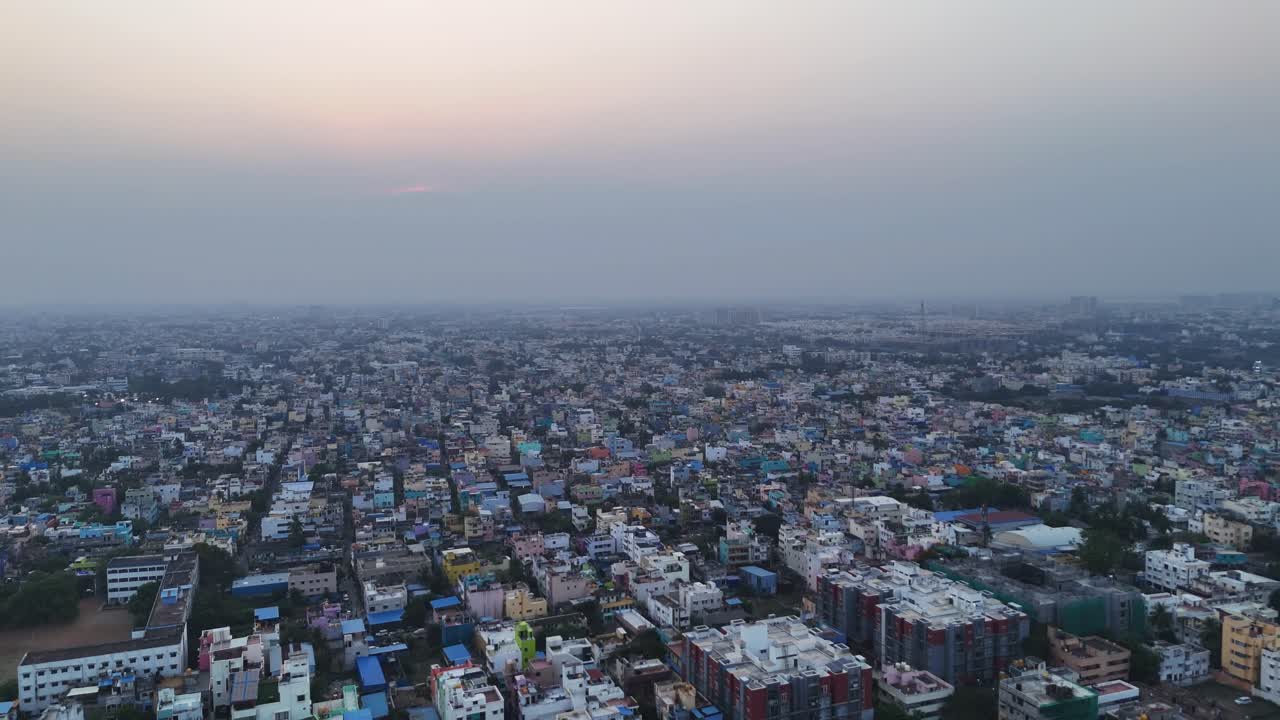 Aerial footage of a vast, densely packed city at dusk. Buildings of ...