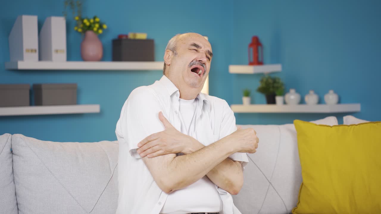 Premium stock video - Sick old man whose bones hurt when he sneezes.