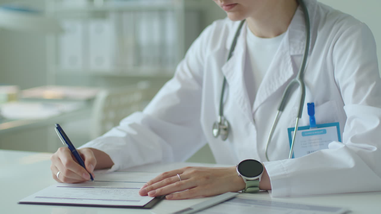 Female Doctor Writing Medical Report at Desk in Clinic | Premium Stock ...