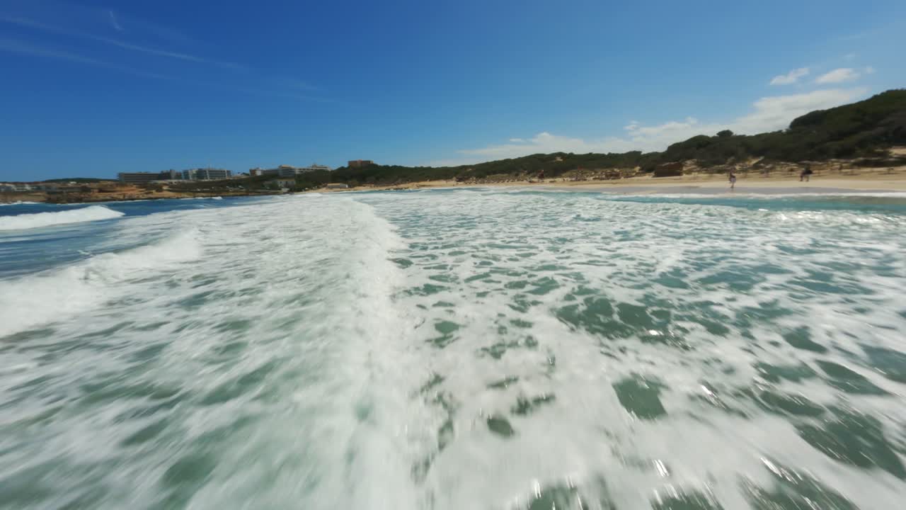 Fpv drone riding the clear blue surf on a beautiful amazing beach day ...