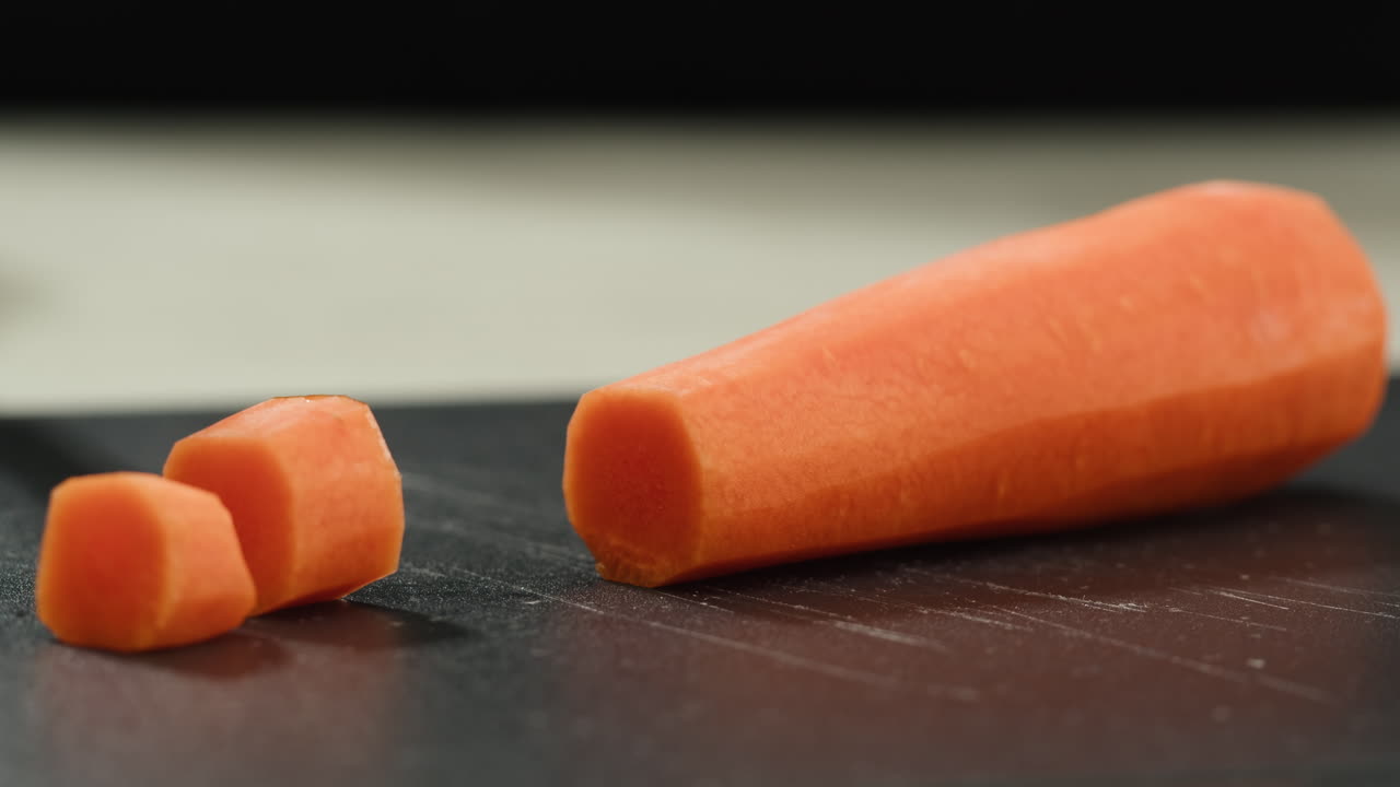 Woman chef cutting carrot, with knife cuts fresh carrot slices for ...