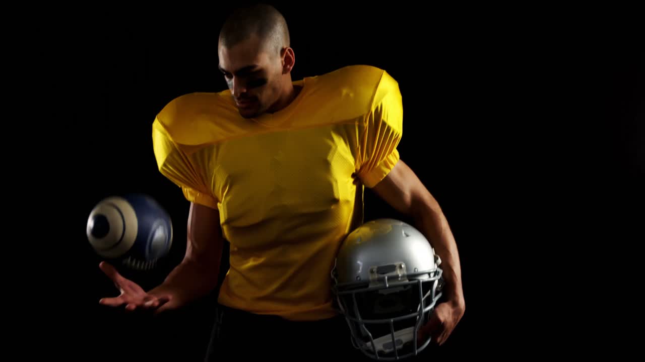 Premium stock video - American football player holding head gear and ...