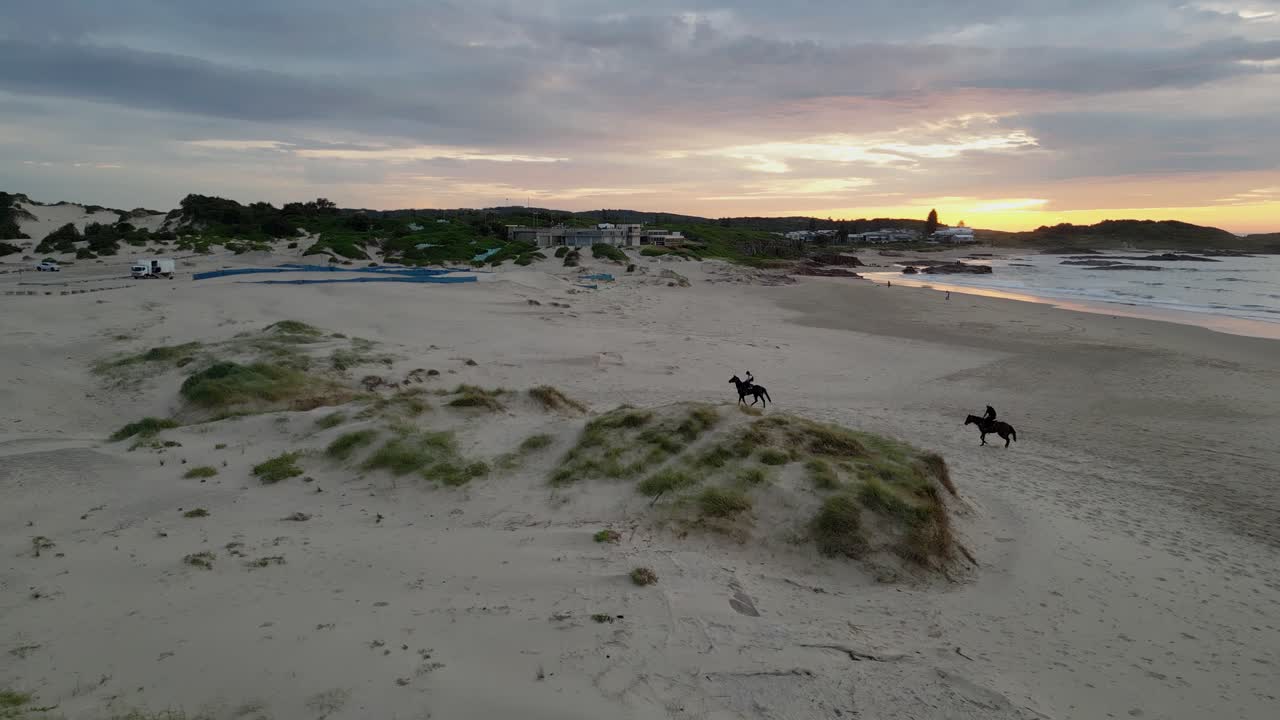 Premium stock video - Two horses riding along the beach at the sand ...