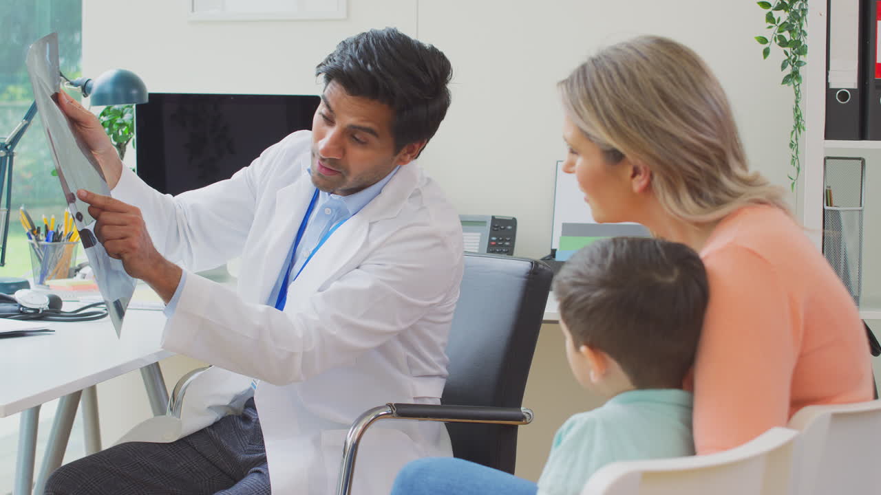 Premium stock video - Doctor in white coat with mother and son in ...