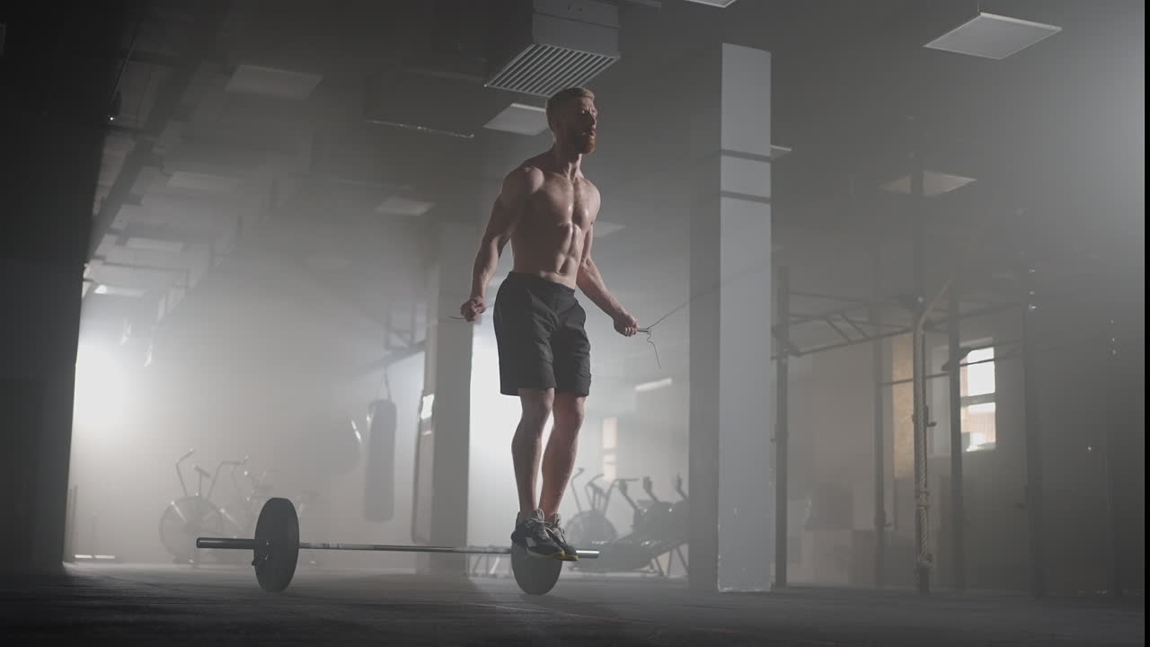 Young man exercising using skipping rope in gym. athletic man training ...