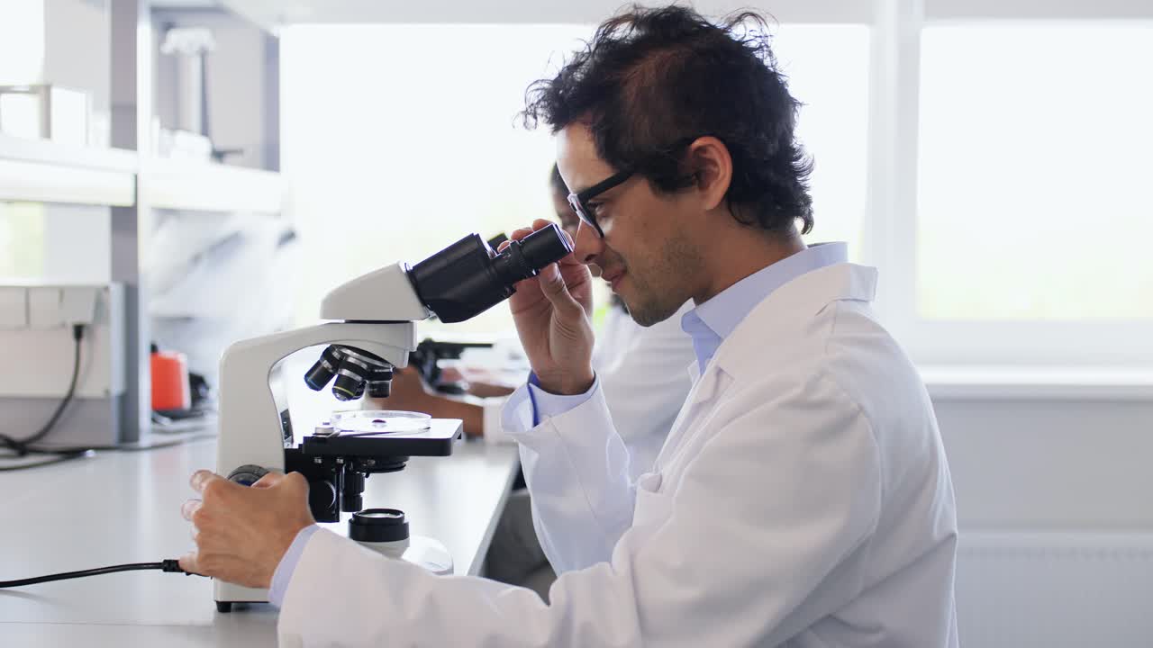 Premium stock video - Scientists with microscopes working in laboratory ...