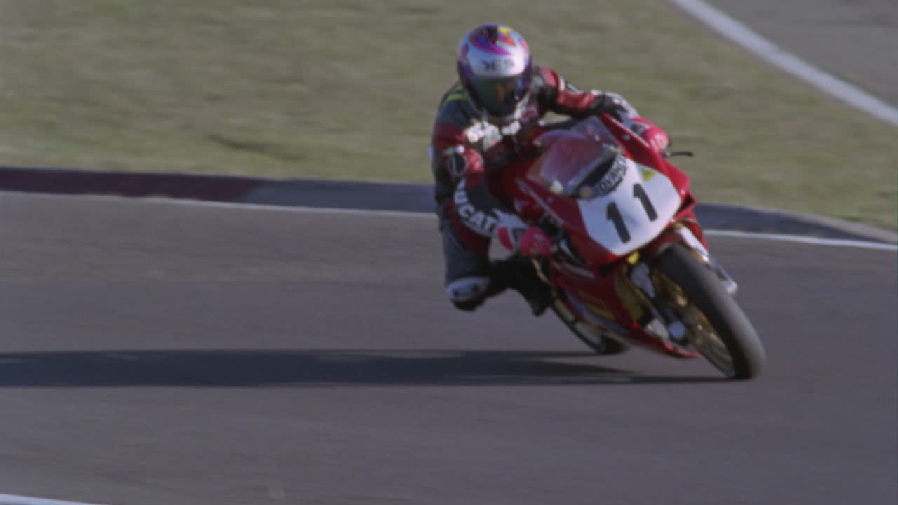 Premium stock video - A motorcycle racer leans into a sharp turn 1