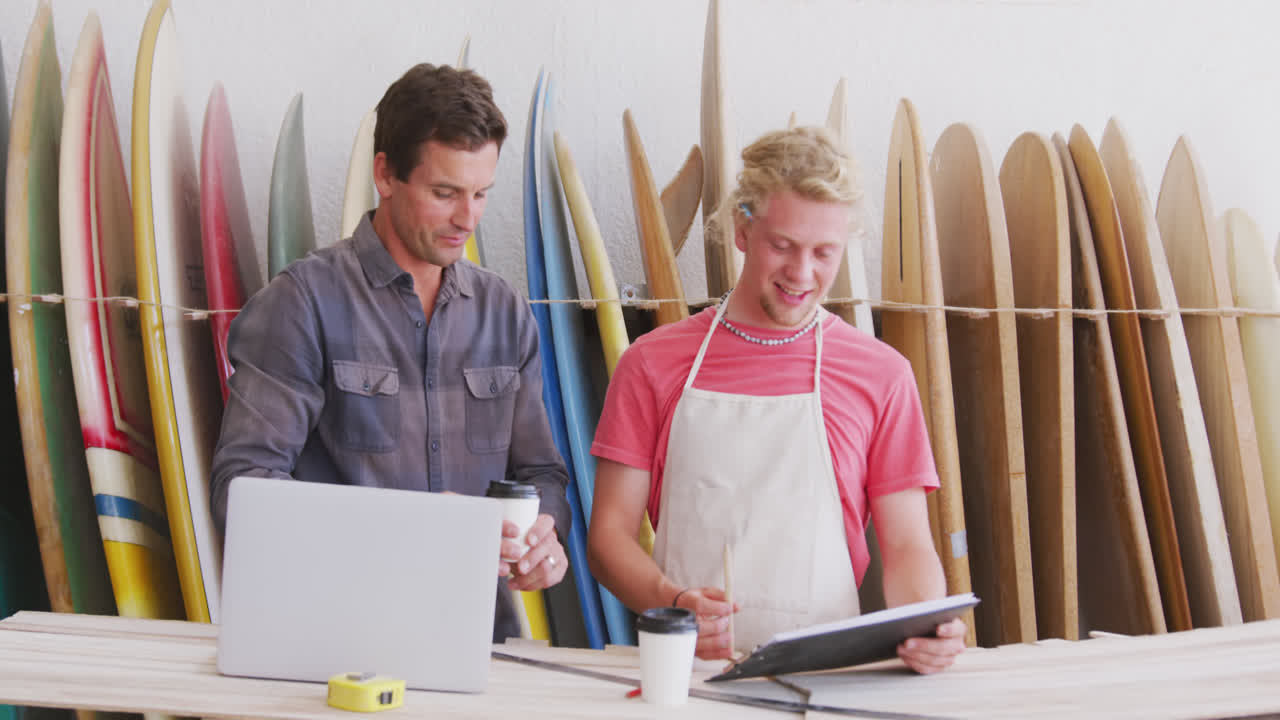 Premium stock video - Two caucasian male surfboard makers working on ...
