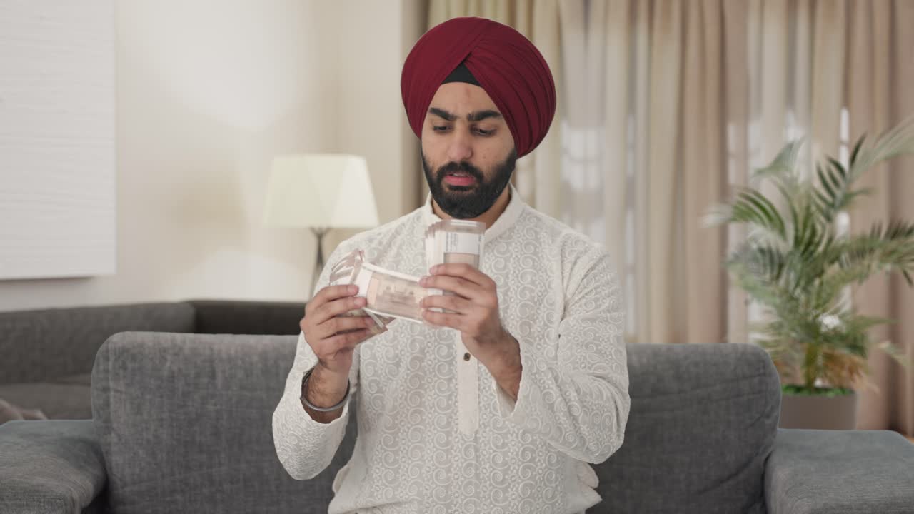 Premium stock video - Sikh indian man counting money