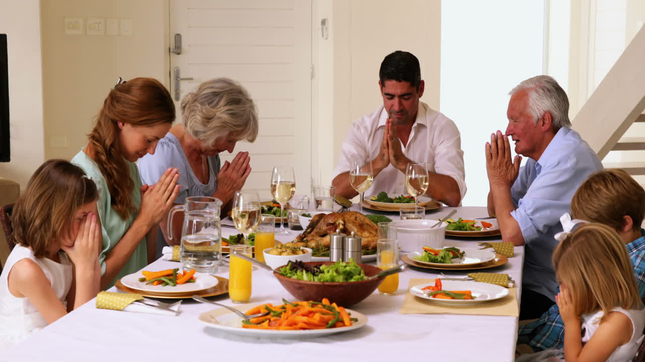 Extended family saying grace together before dinner Premium Stock Video ...