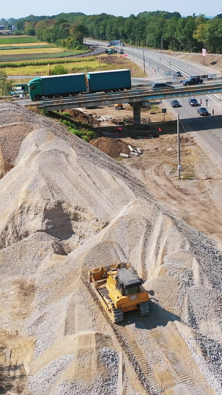 Trucks are working near the highway. Cars moving on the road. New ...