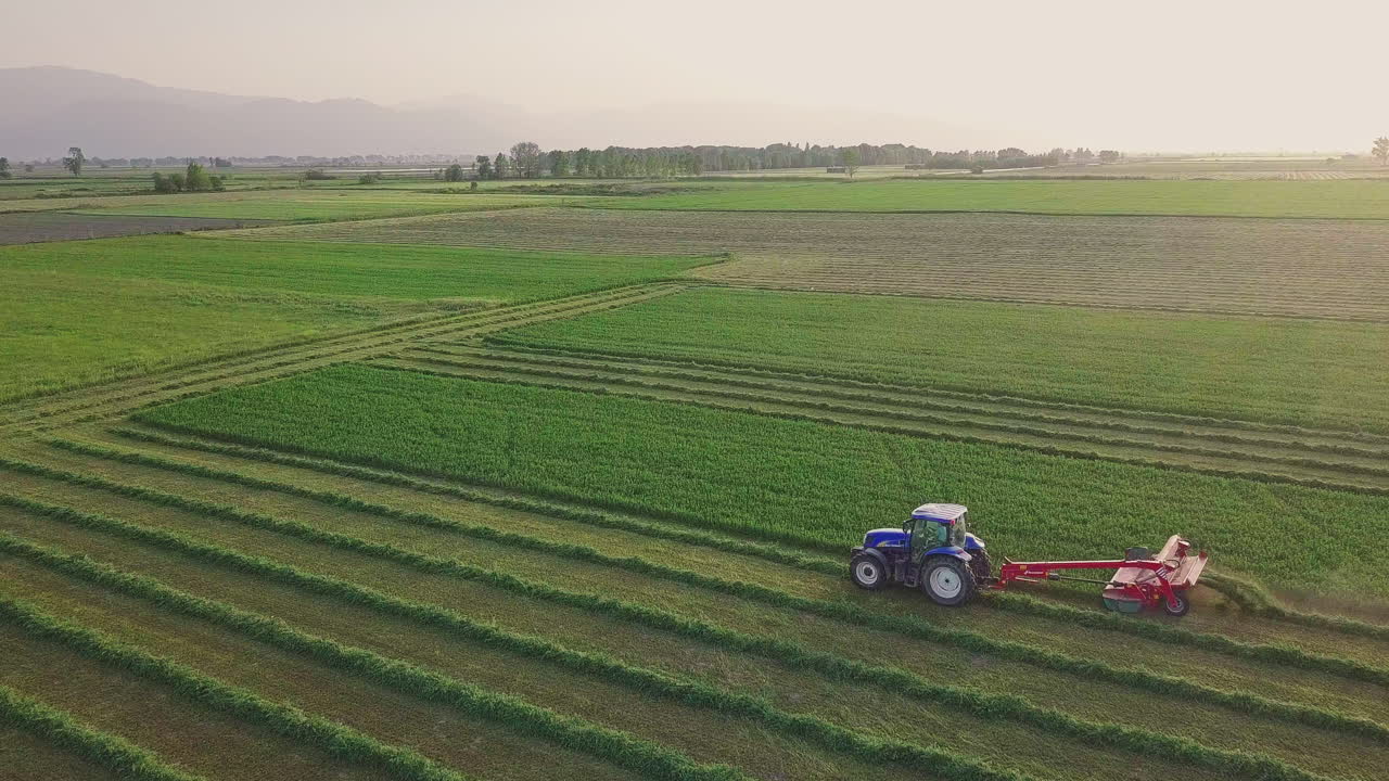Farmer drives tractor plowing field at sunset in rural farmland, 4k ...