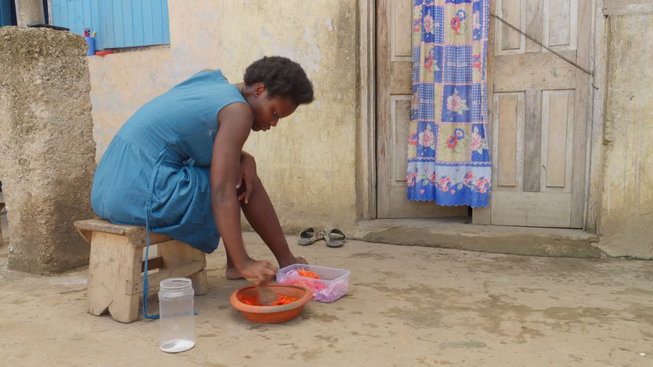 African woman mashing vegetables to eat with banku, leavened flour ...