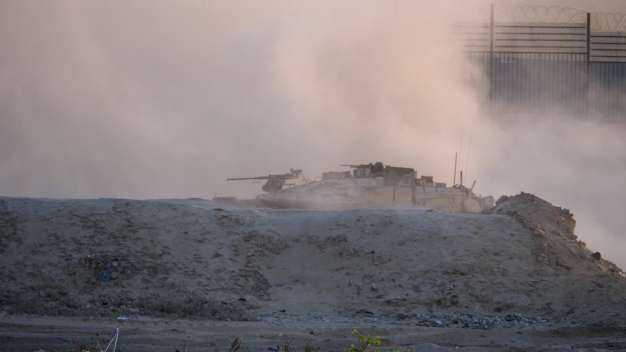 Israeli tank advancing behind a mound mound concealed by smoke in Gaza ...
