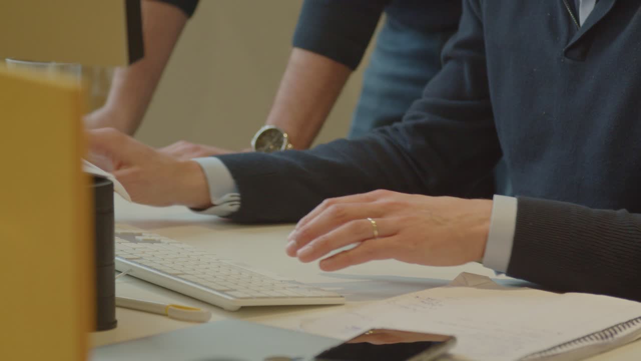 Premium stock video - Hands of man sitting behind keyboard while a co ...