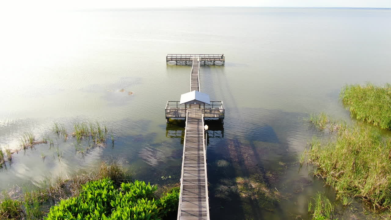 Flying over a florida lakeside dock on a beautiful, calm spring evening ...