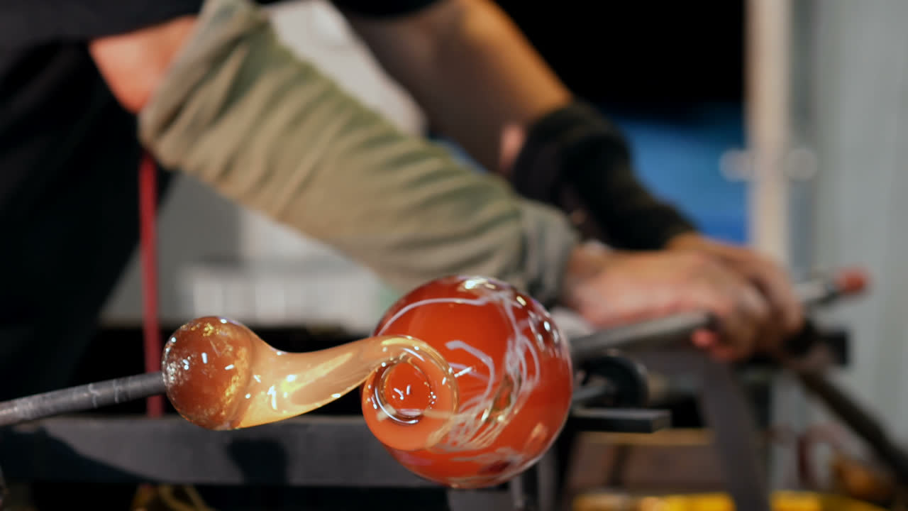 Glassblower shaping a molten glass | Premium Stock Video Footage