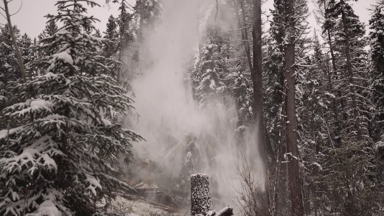 Tight close shot industrial timber manipulator saw machine takes snow ...