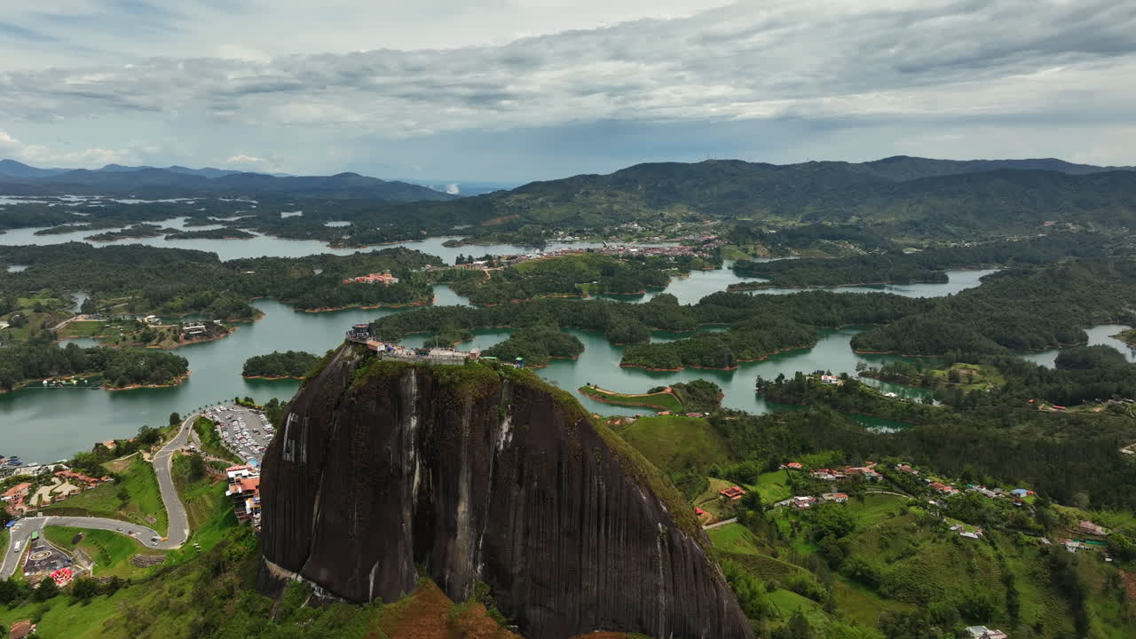 Drone shot over the el peñón rock, toward the reservoir, in cloudy ...