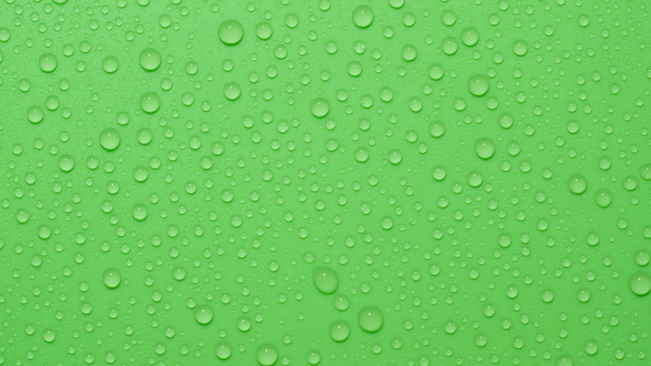 Close-up transparent water drops texture rotating on green chroma key ...