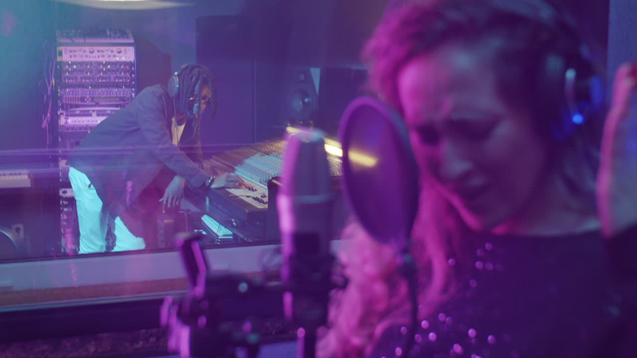 Vídeo Premium - Mujer grabando una canción con un productor musical en ...