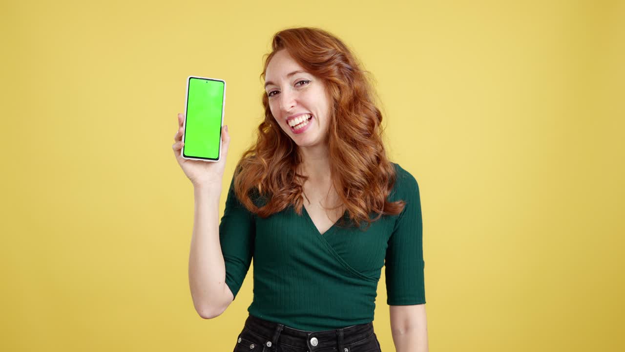 Red-haired woman showing a green screen smartphone | Premium Stock ...