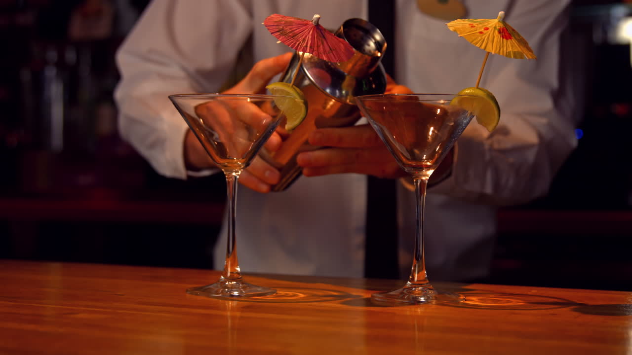 Premium stock video - Bartender pouring cocktails on counter