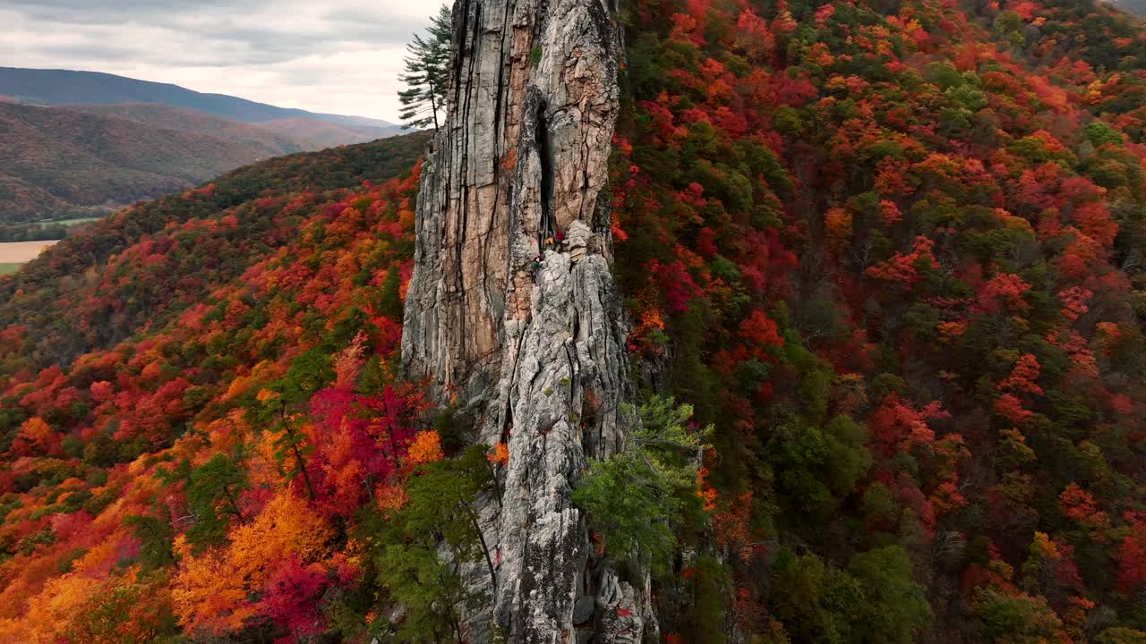 Climbers scaling cliff in seneca rocks west virginia during peak fall ...