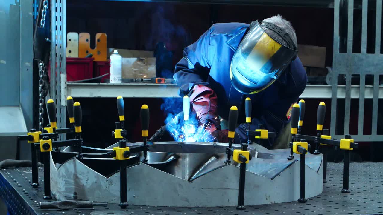 Premium stock video - Welder in protective uniform conducting welding ...