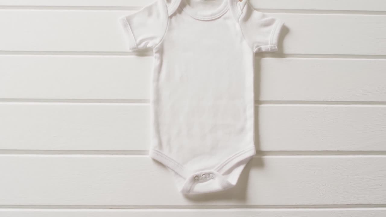 Premium stock video - Video of close up of white baby grow on white ...