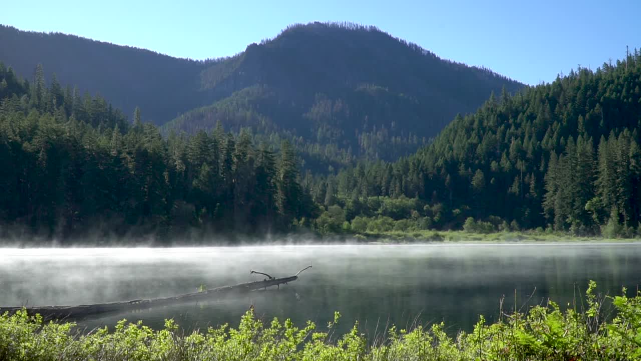 Premium stock video - High altitude lake steaming on a cold morning