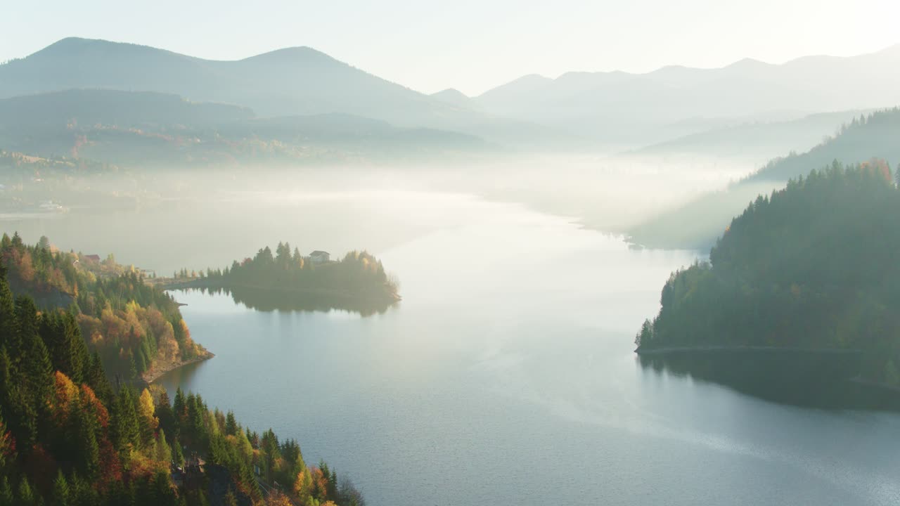 The aerial photo captures an island on a forested lake, visible through ...