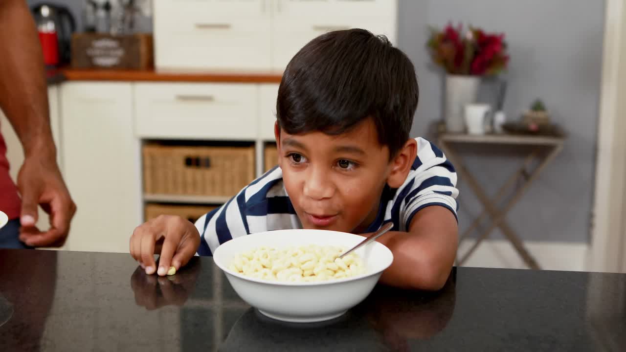Premium stock video - Boy having breakfast in kitchen 4k