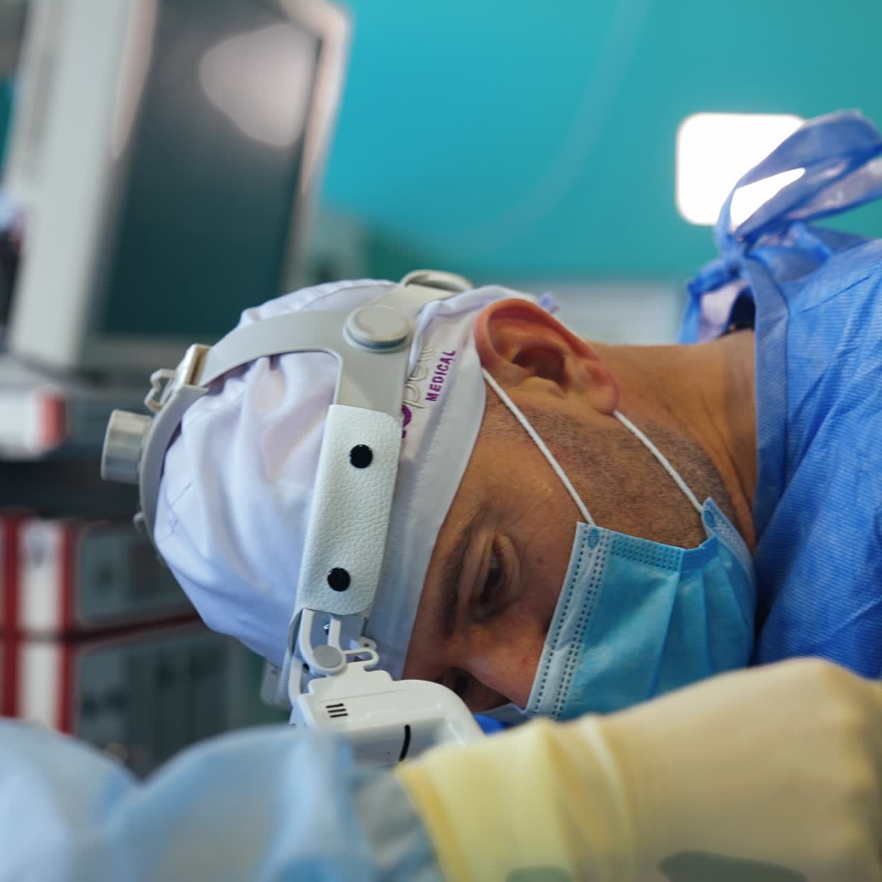 Surgeon bending low over the patient performing breast operation ...