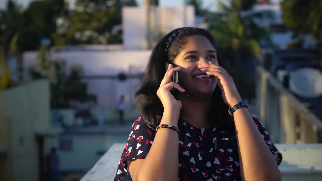 Premium stock video - A girl talking in her phone during sunset