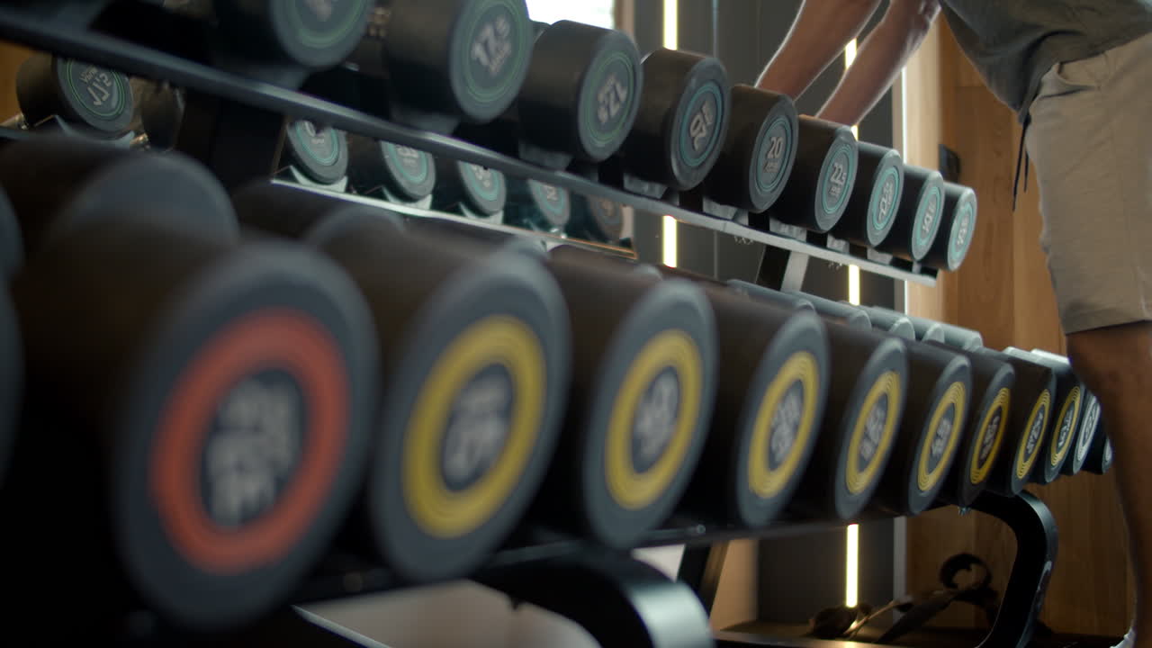 Strong bodybuilder hands putting down equipment at gym. Macro of heavy ...