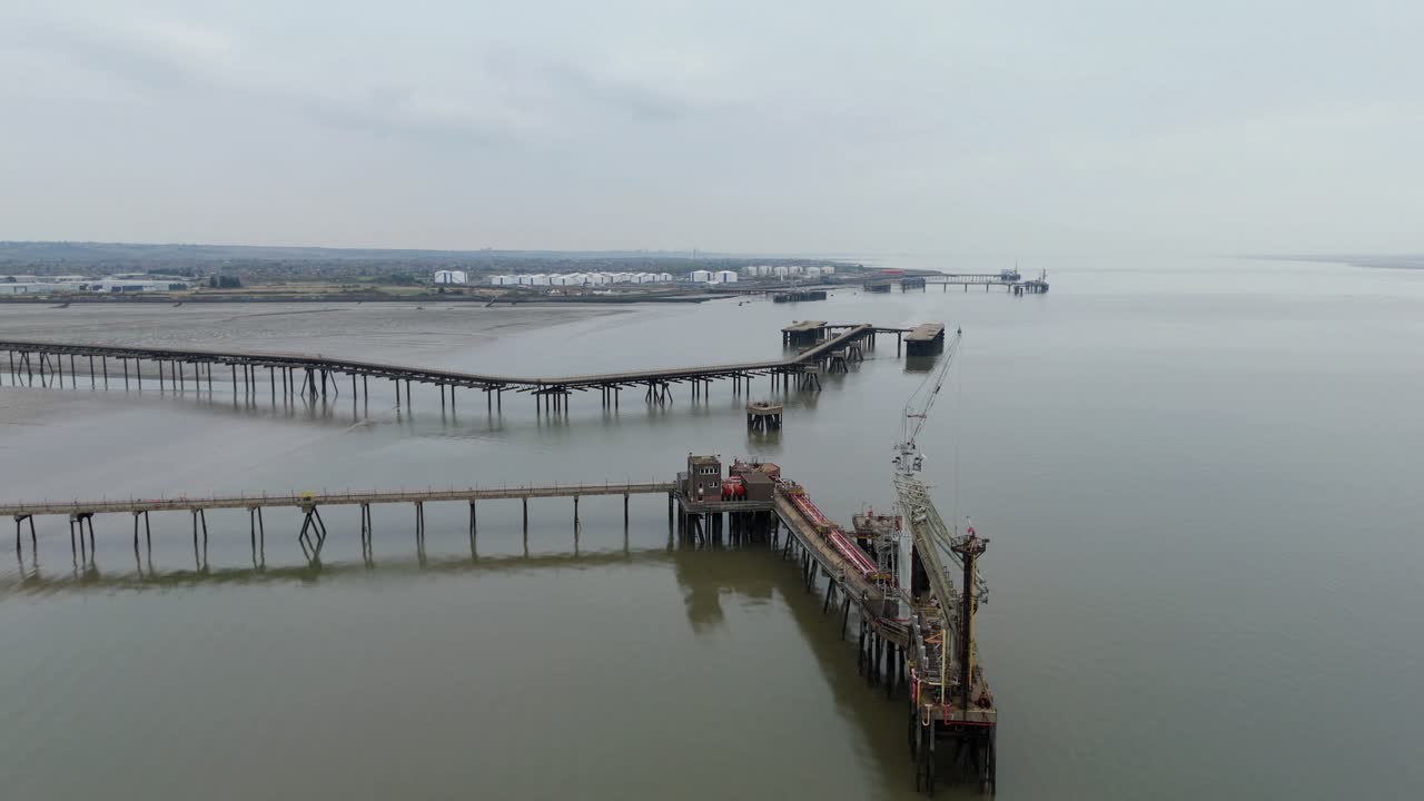 Top-down aerial drone sweep of Canvey Island industrial piers, showing ...