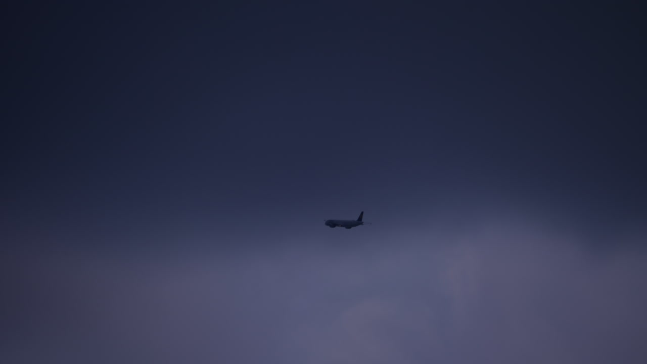 Airplane Flying in a Dark Cloudy Sky | Premium Stock Video Footage