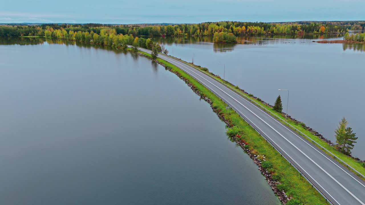 Wide shot of a land bridge road highway with cars crossing a lake in ...