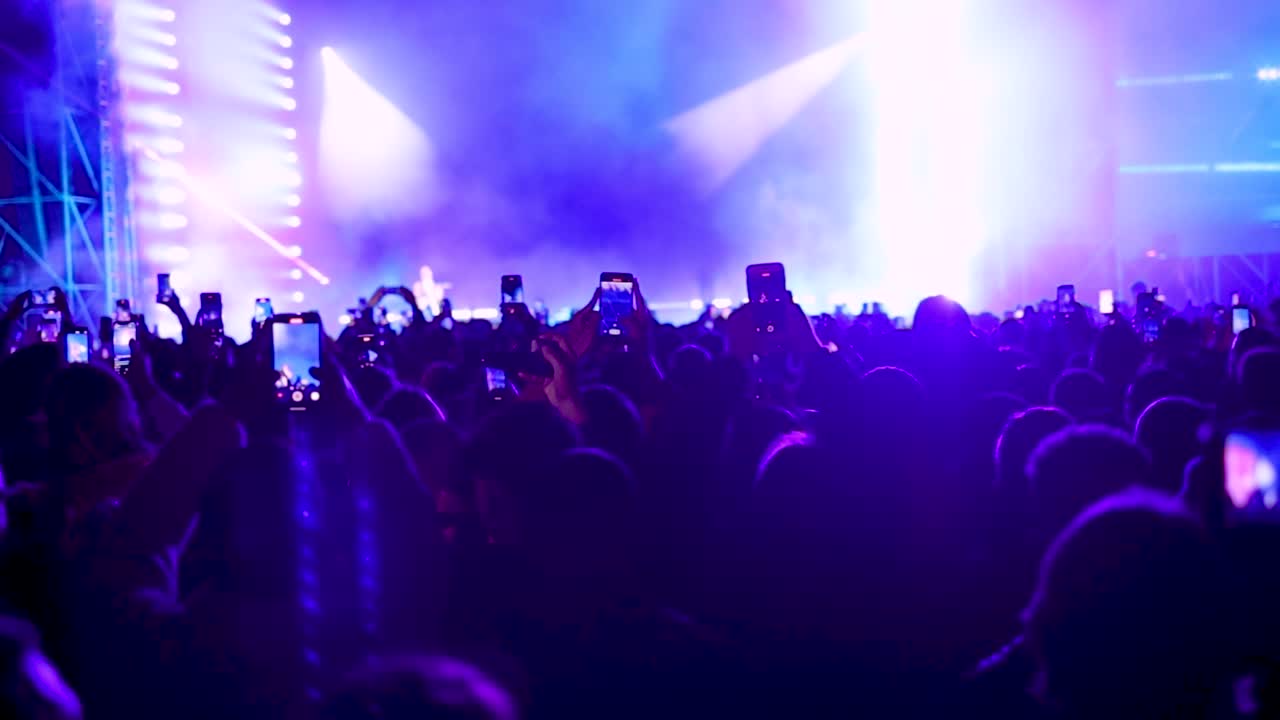 Man in a crowd recording live show on stage with smartphone | Premium ...