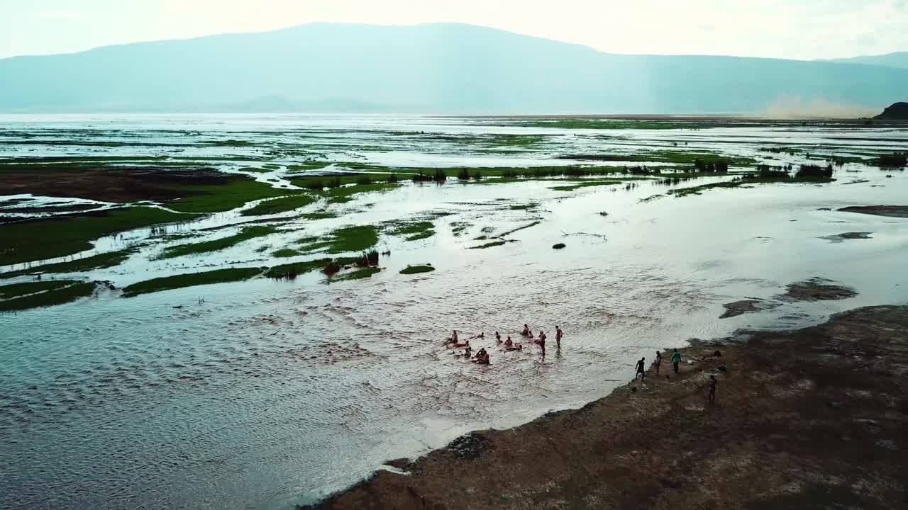 Premium stock video - Lake natron with tourists enjoying the water in ...