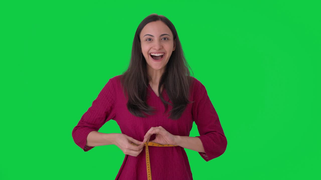 Premium stock video - Happy indian woman measuring her waist using inch ...