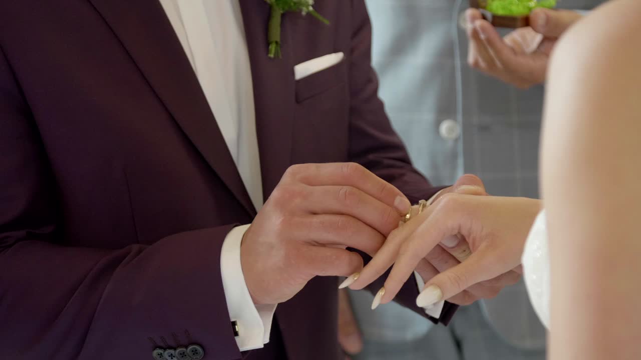 Premium stock video - Wedding ceremony, groom placing the ring on the ...