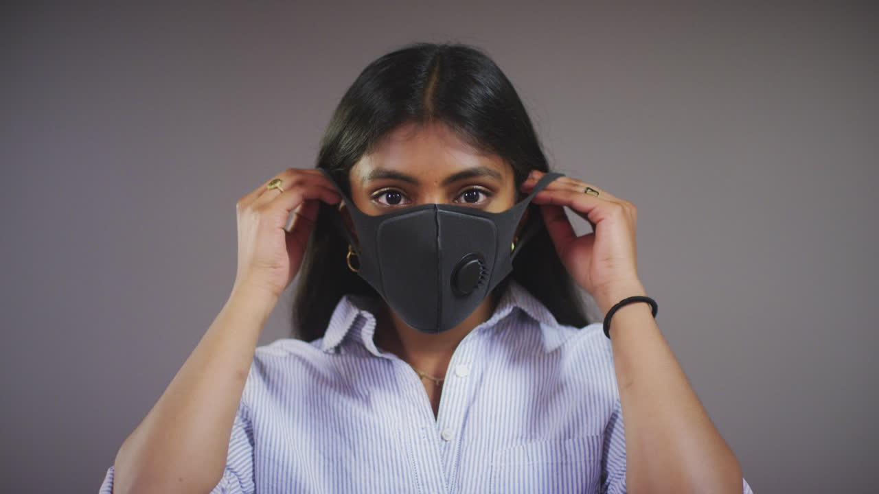 Free stock video - Young woman puts on face mask