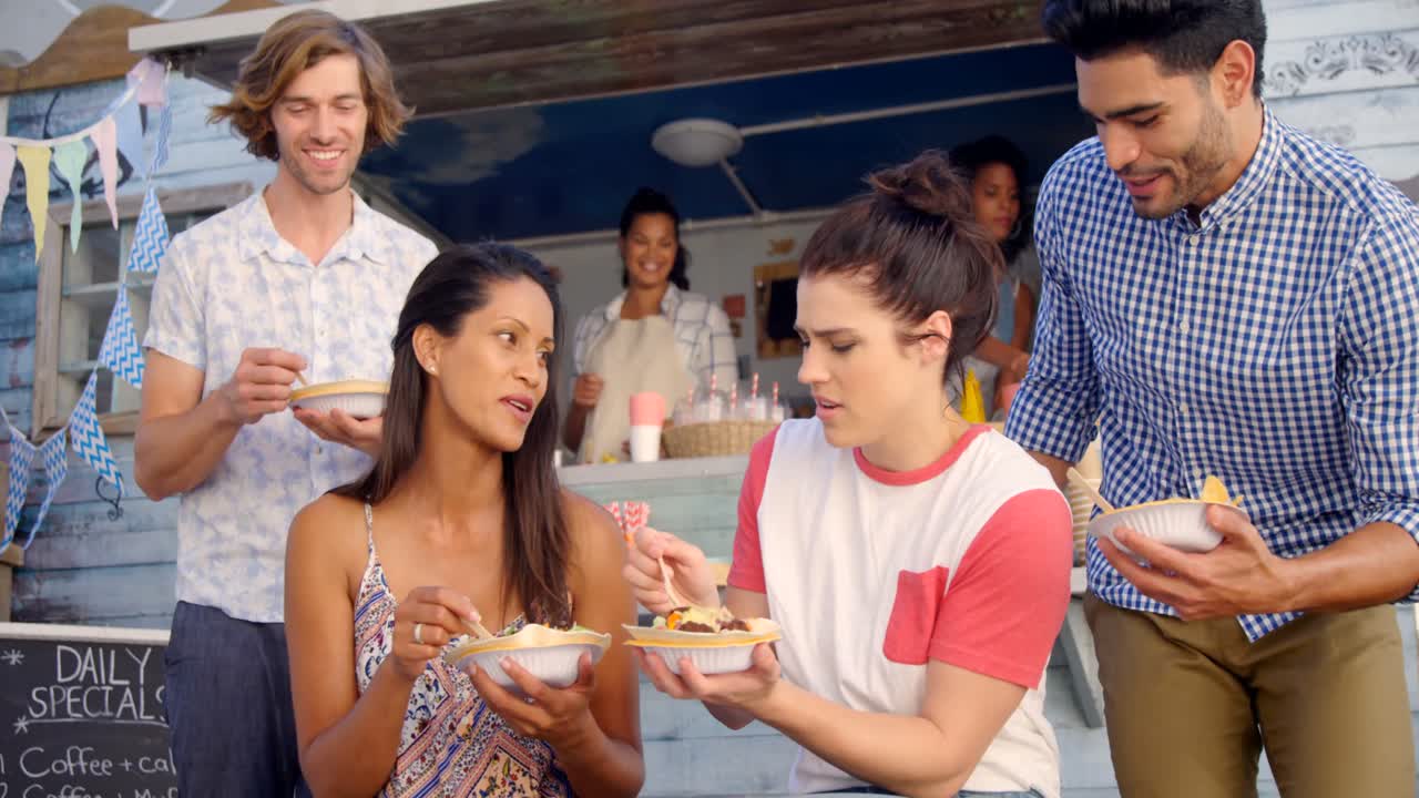 Premium stock video - Smiling friends eating snacks