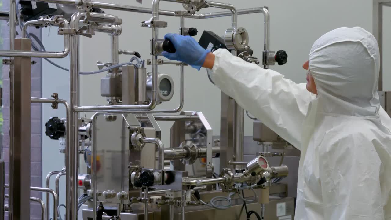 Premium stock video - Scientist in protective suits working on vat