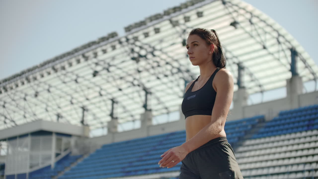 Slow motion portrait of beautiful woman running on the stadium ...