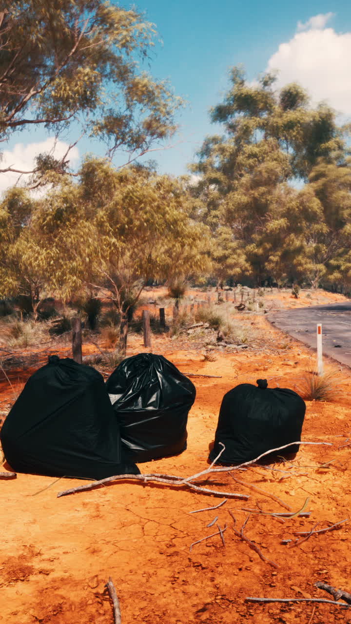 Premium stock video - Garbage bags on a dirt road in the australian outback