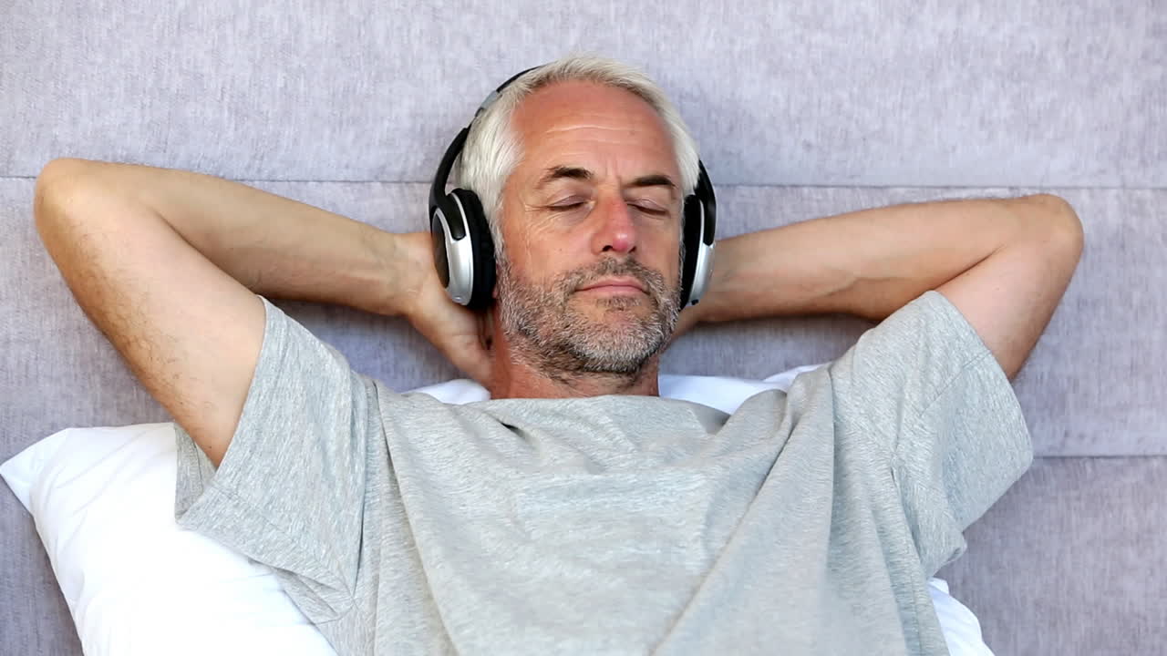 Premium stock video - Man relaxing while listening to music
